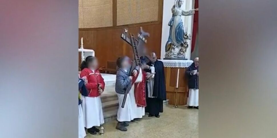 Il chierichetto non tiene bene la croce che cade sulla testa del prete ...